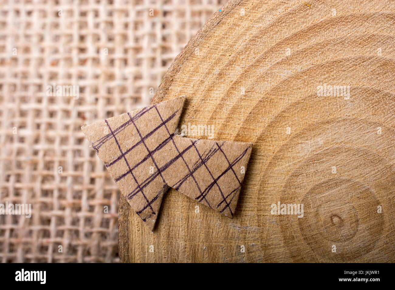 Arrow sign cut out of brown paper on piece of wood Stock Photo - Alamy