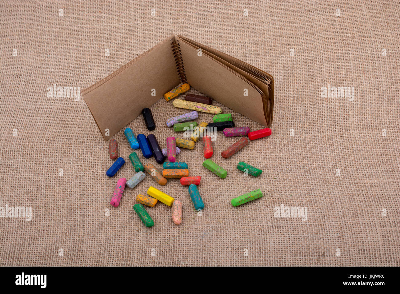 Notebook beside some colorful crayons Stock Photo - Alamy