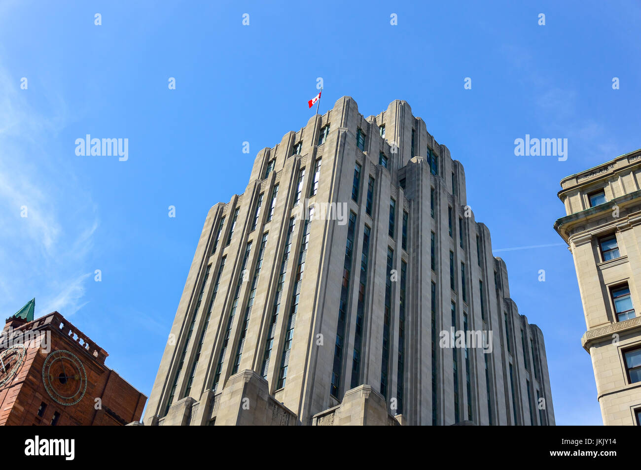 An old historical building with the large windows and the Canadian flag ...