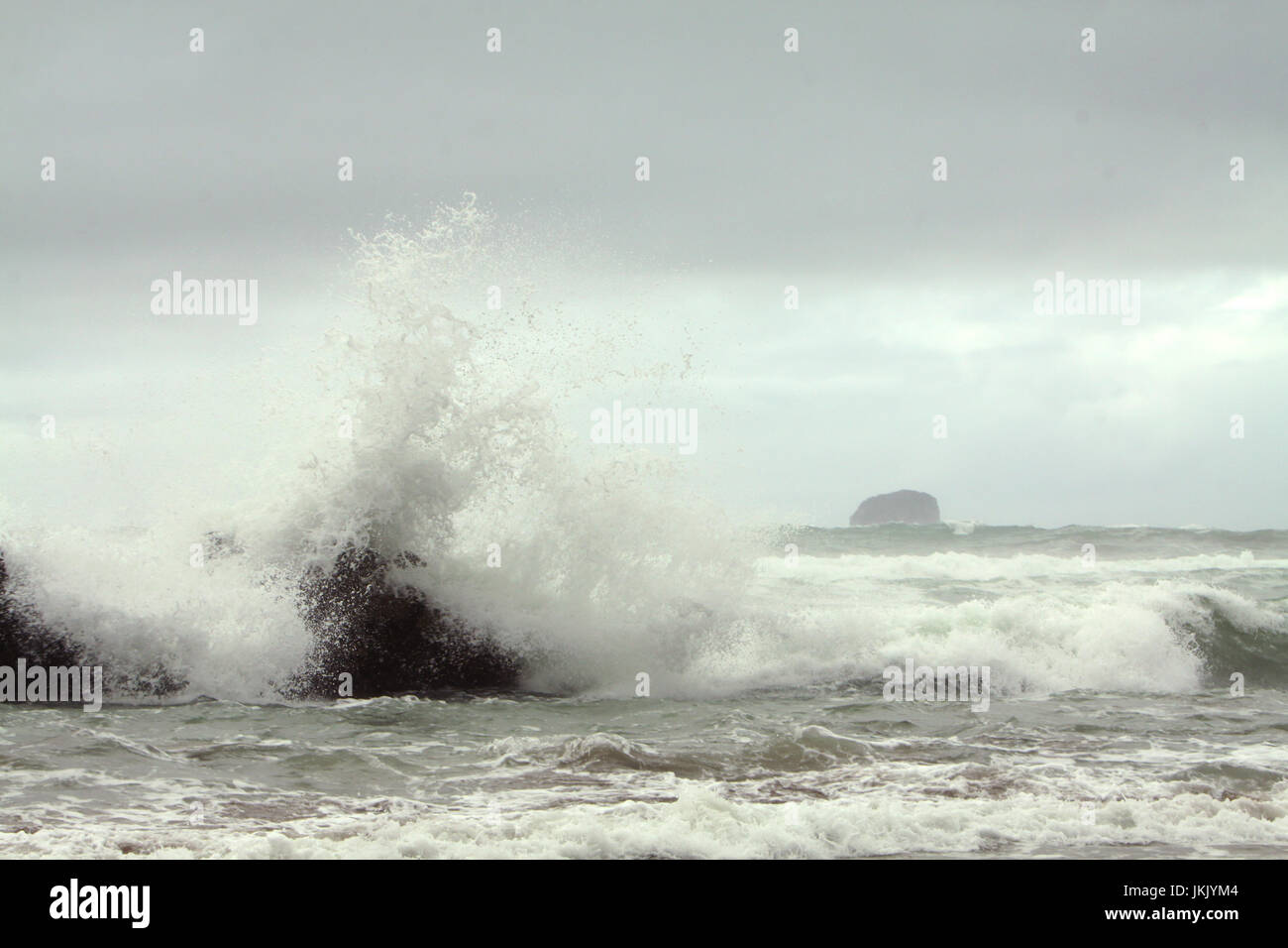 Wave crashing on rock Stock Photo - Alamy