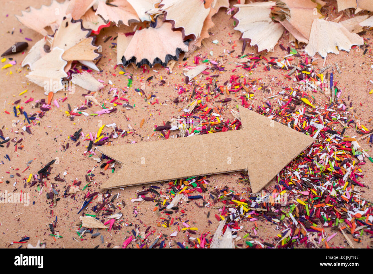 Arrow cut out of paper amid pencil shavings on canvas Stock Photo - Alamy
