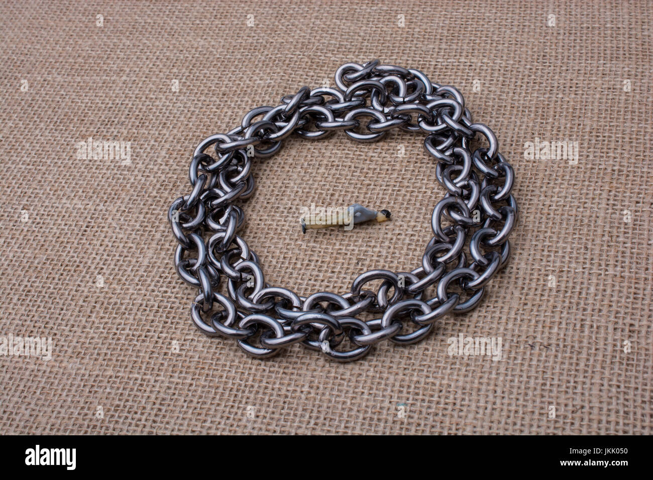 Man figurine trapped in the circle of a chain Stock Photo - Alamy