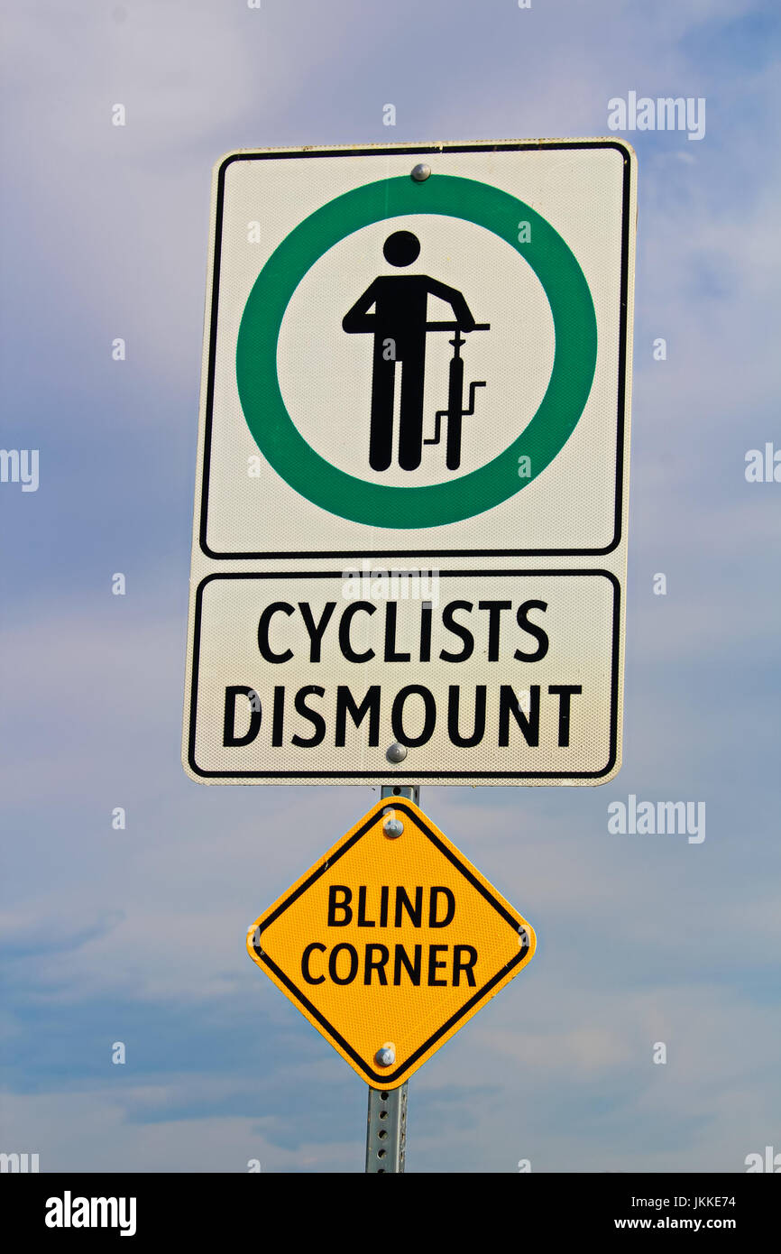 A cyclists dismount sign with a blind corner warning Stock Photo - Alamy