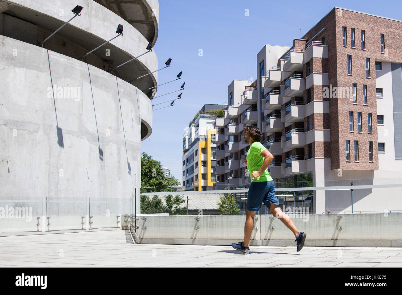 Young man running on the street in urban environment at sunny day Stock ...