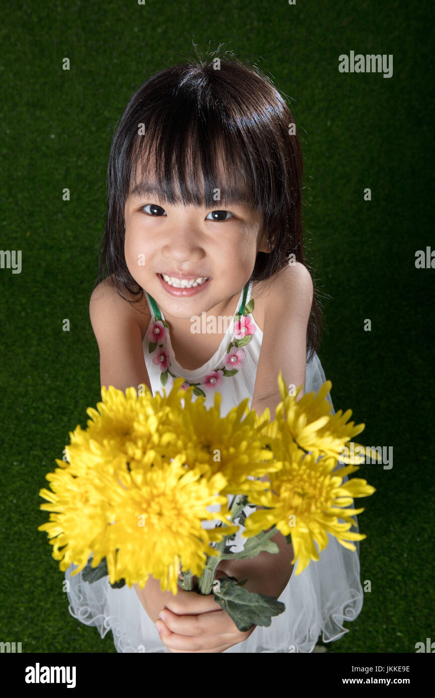 Asian Chinese little girl holding flowers at outdoor park Stock Photo ...