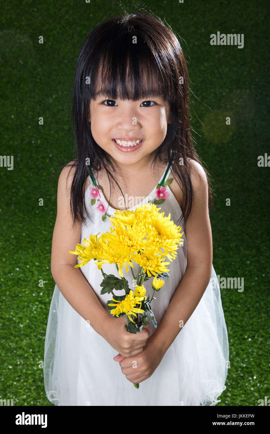 Asian Chinese little girl holding flowers at outdoor park Stock Photo ...