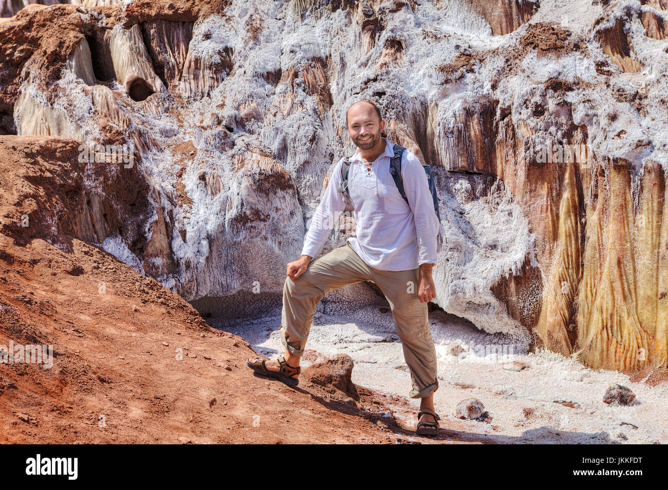 Smiling tourist posing for a photographer against the backdrop of ...