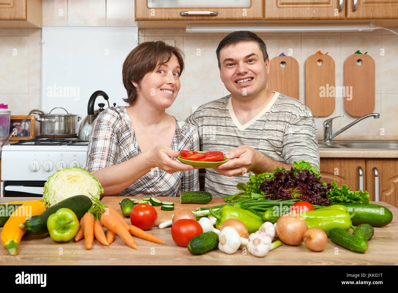 couple cooking in kitchen interior with fresh fruits and vegetables ...