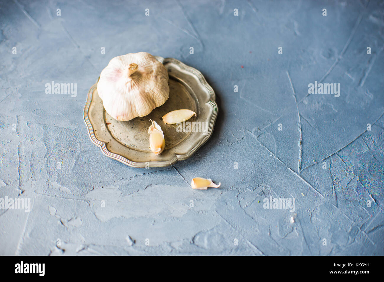 Garlic Cloves and Garlic Bulb on red vintage bowl on grey concrete ...