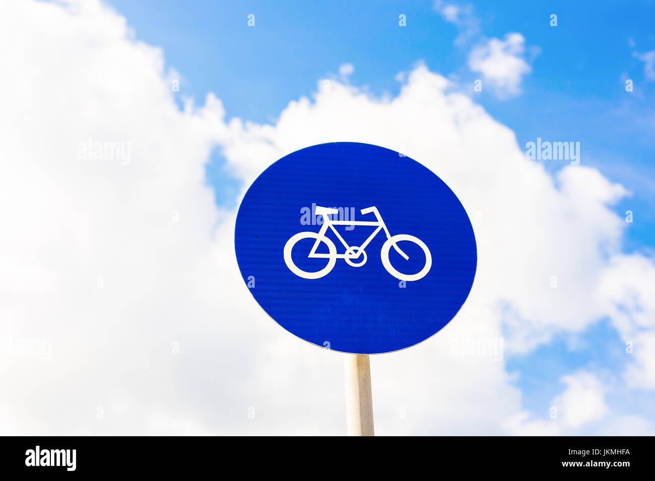 round bicycle lane sign against a blue sky Stock Photo - Alamy