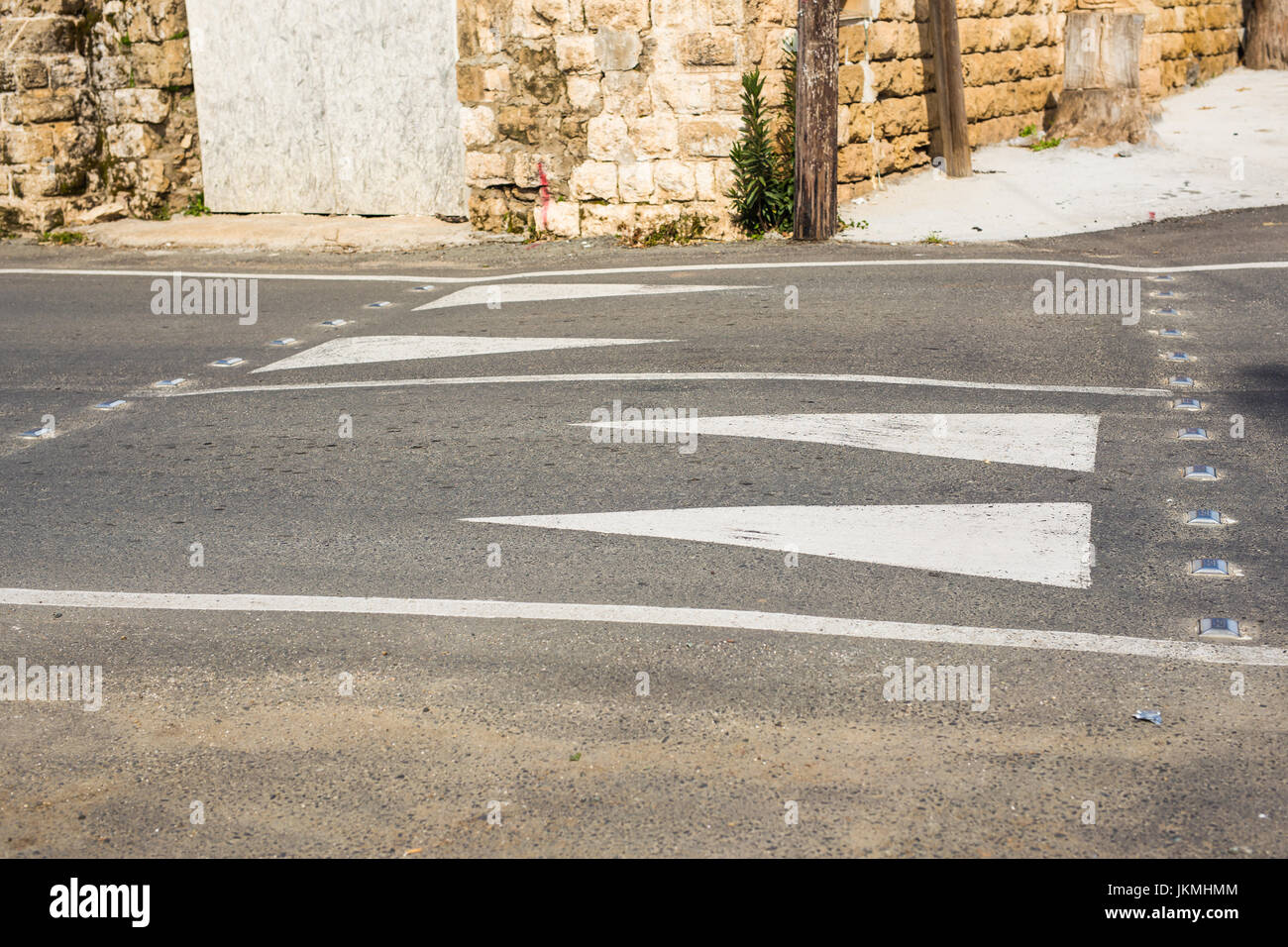 arrow road markings and concrete road barrier Stock Photo - Alamy