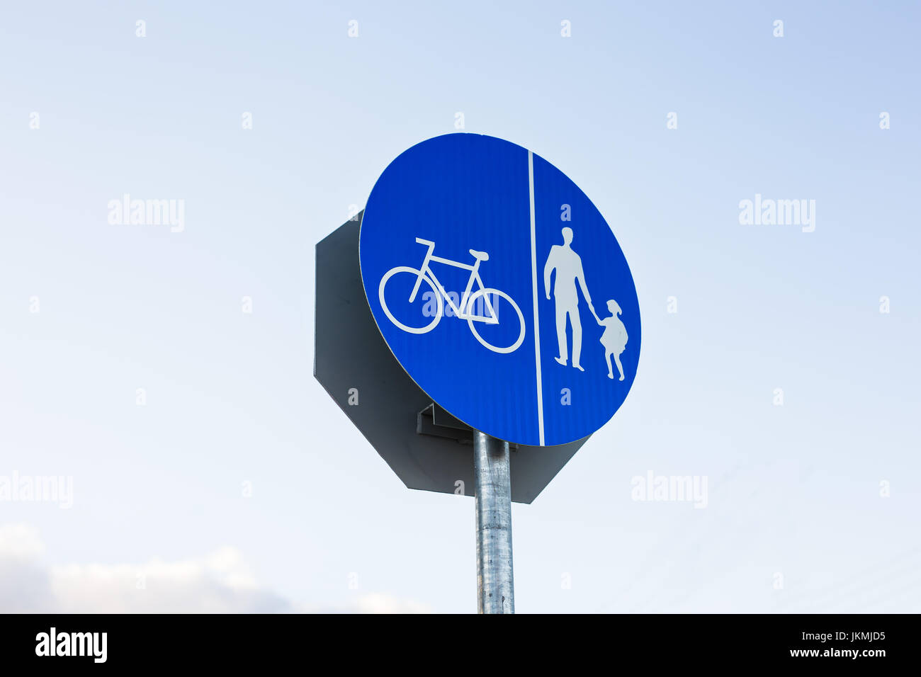 round bicycle lane sign against a blue sky Stock Photo - Alamy