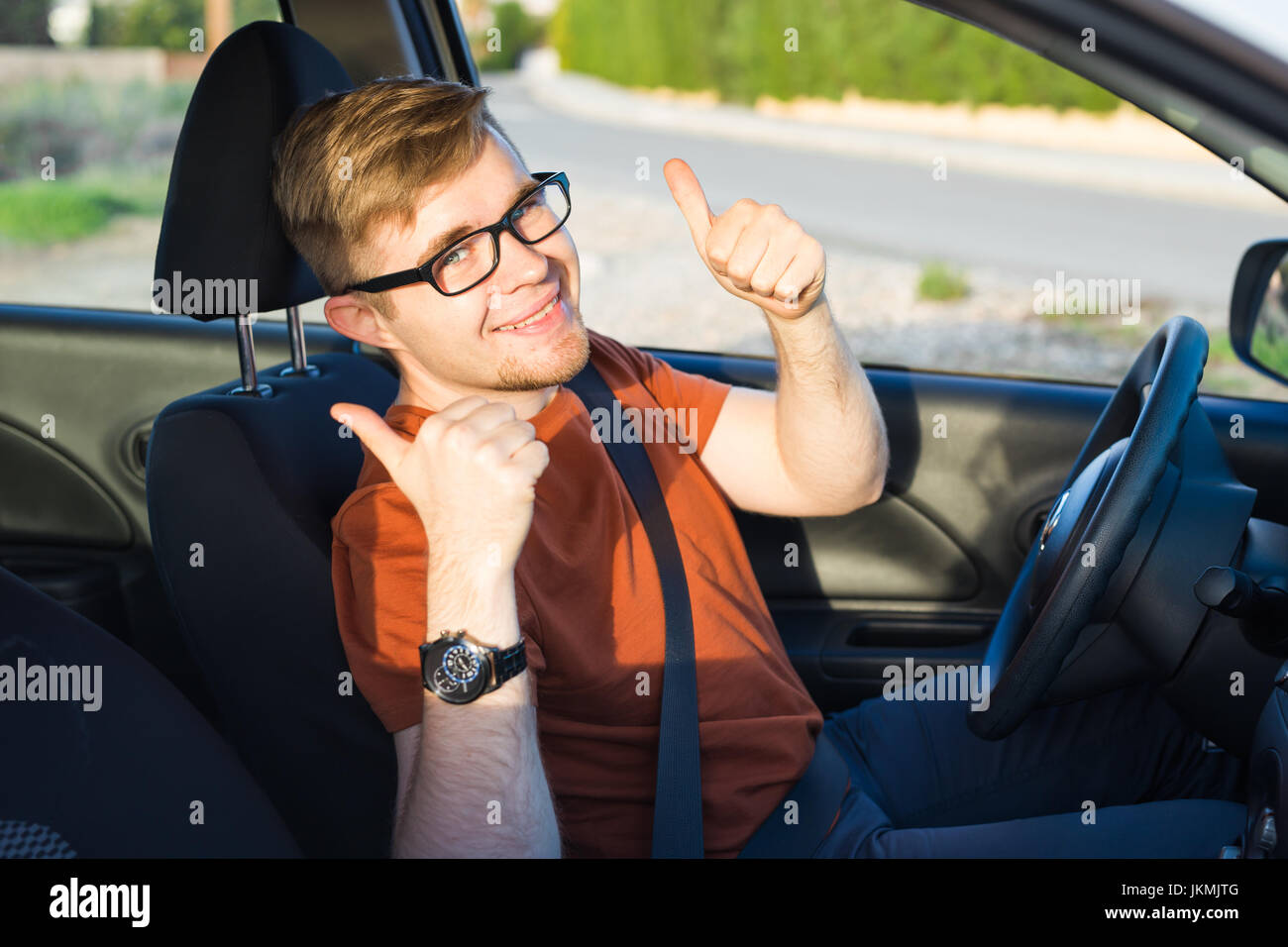 Happy car owner is showing thumbs up inside his new car Stock Photo - Alamy