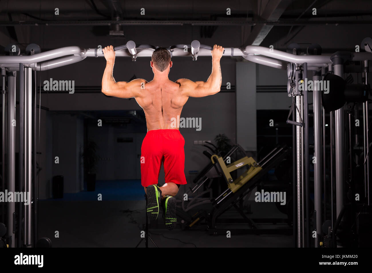 Strong man doing pull-ups on a bar in a gym Stock Photo - Alamy