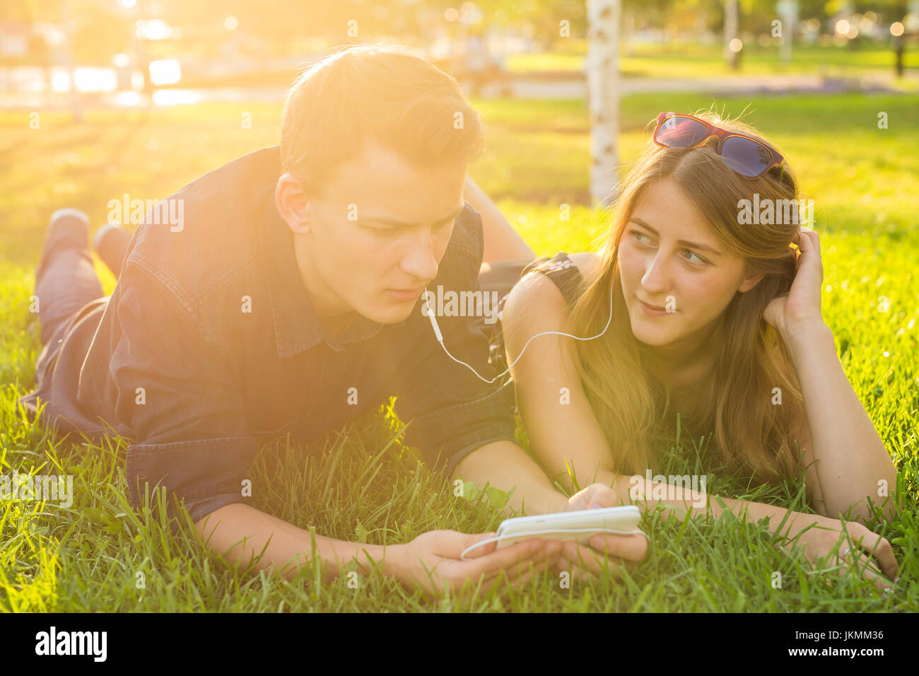 Loving young couple in summer park listening music Stock Photo - Alamy
