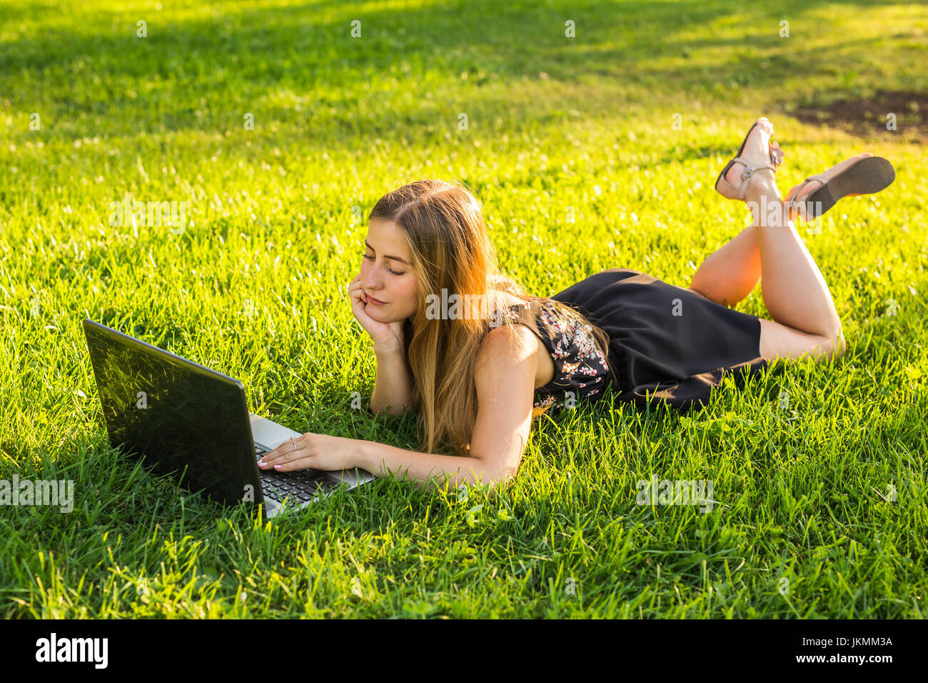 Young girl with laptop working outdoor Stock Photo - Alamy