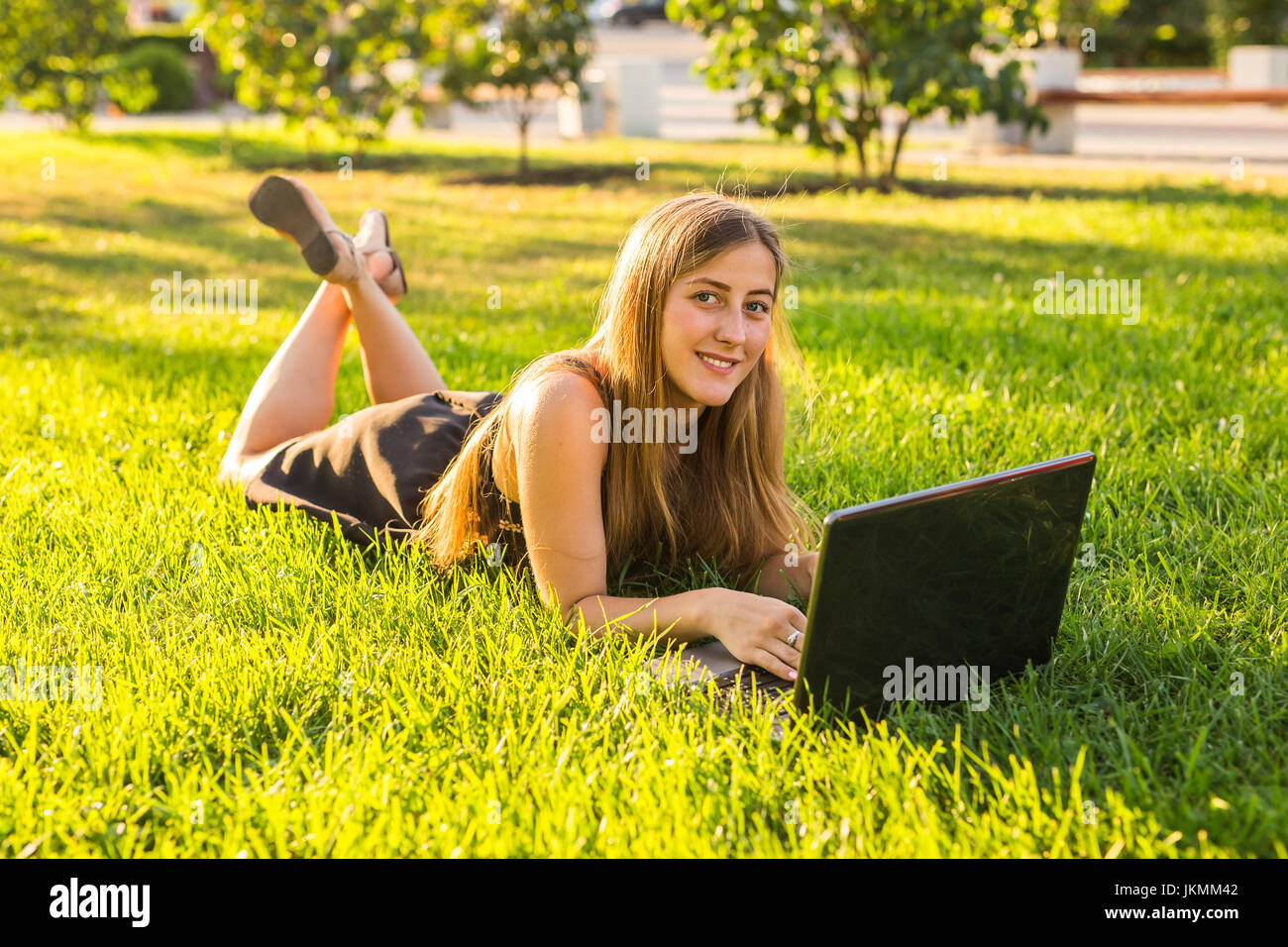 Young girl with laptop working outdoor Stock Photo - Alamy