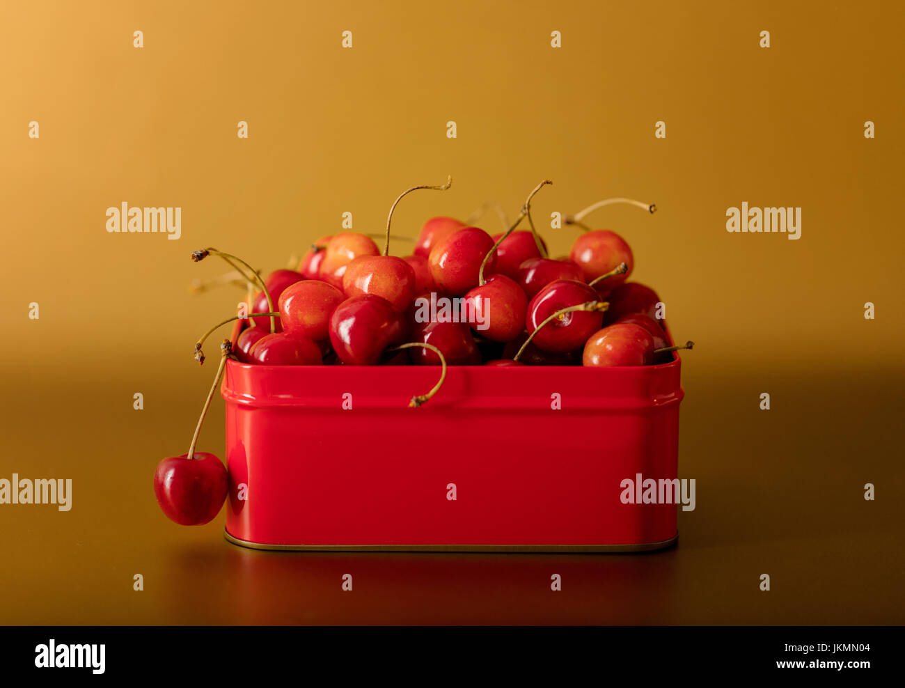 Cherries in a red metal box on a gold background. Selective focus Stock ...
