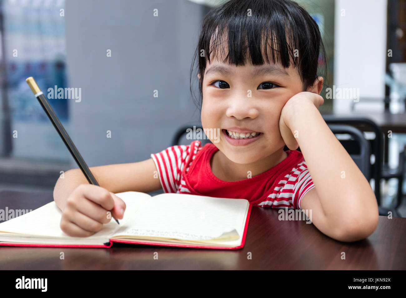 Asian Chinese little girl doing homework at outdoor cafe Stock Photo ...