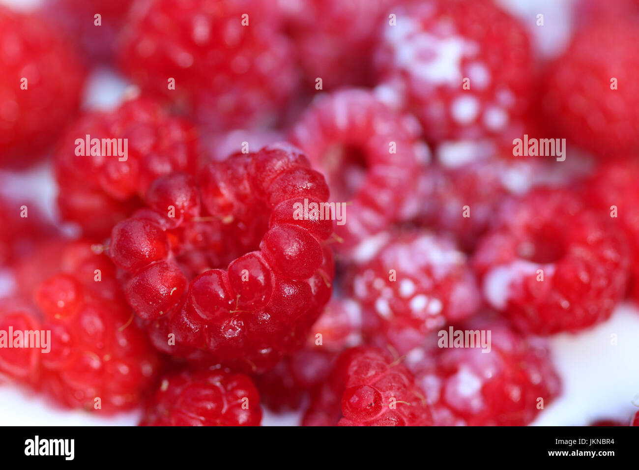 A background of ripe red raspberry with milk Stock Photo - Alamy