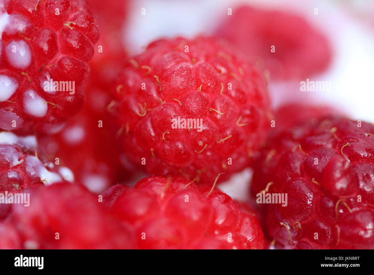 A background of ripe red raspberry with milk Stock Photo - Alamy