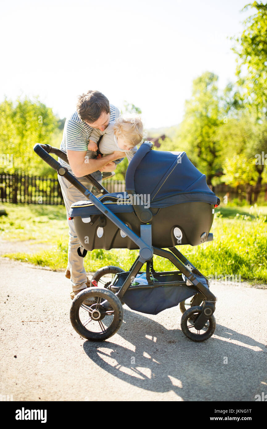 Father with little son and baby daughter in stroller. Sunny park Stock ...