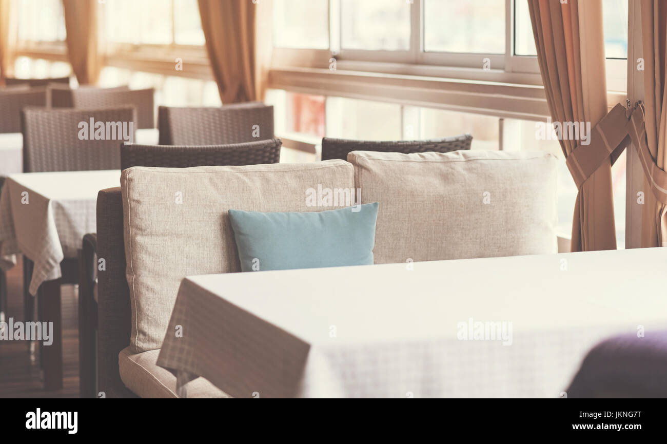 Close up of comfortable seats and tables standing near the window Stock ...