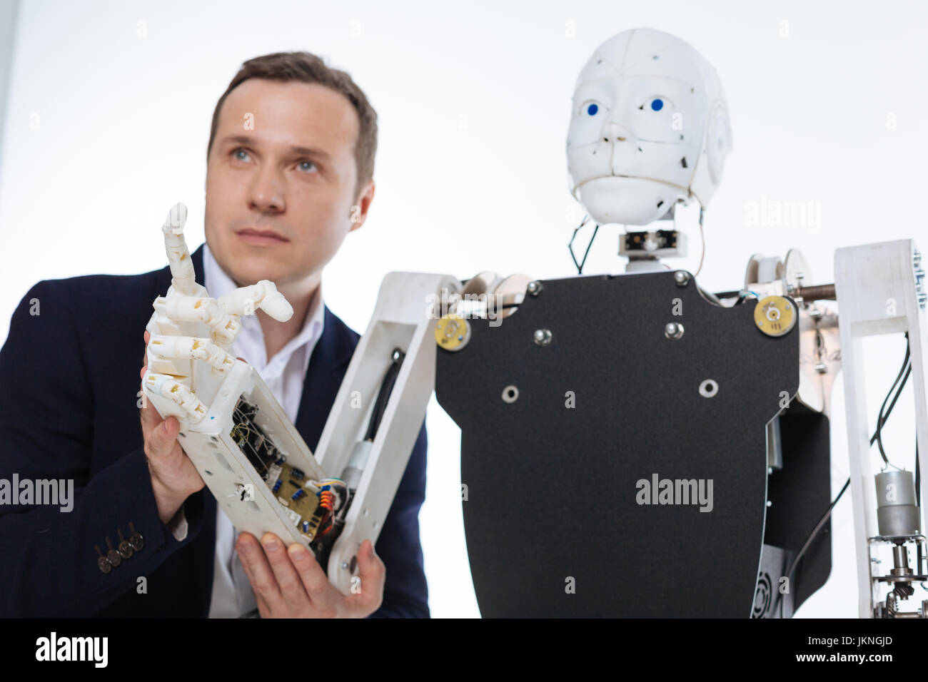 Delicate excited man holding the robot by the hand Stock Photo - Alamy