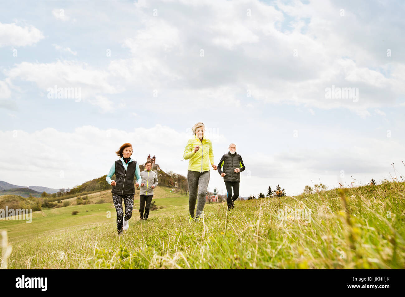 Group of seniors running outside on green hills Stock Photo - Alamy