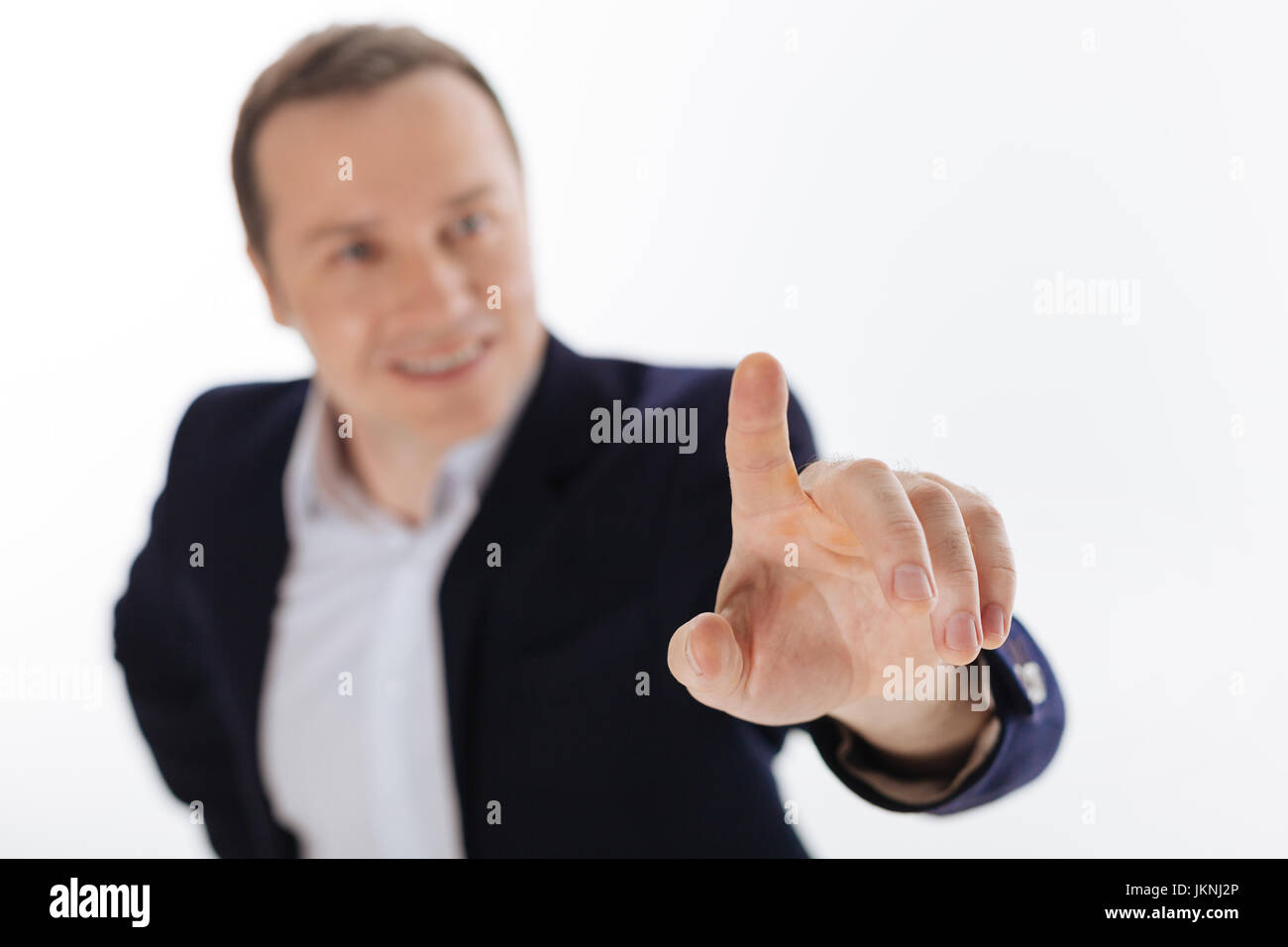 Handsome energetic guy reaching out to touch something Stock Photo - Alamy