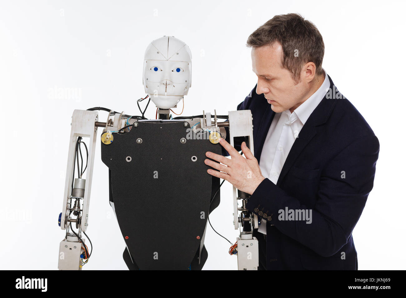 Fascinated bright scientist studying complex mechanisms of the robot ...
