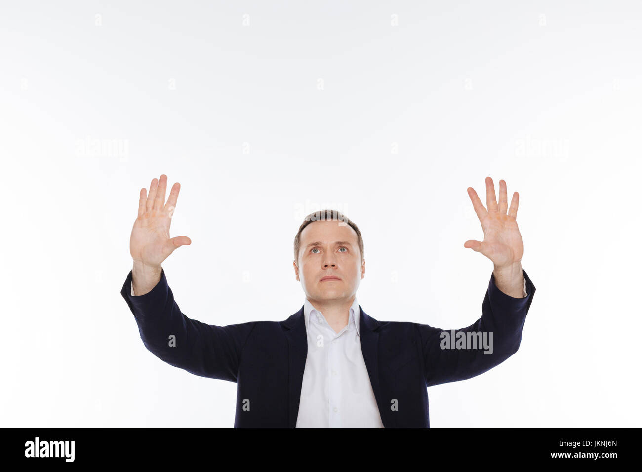 Handsome focused gentleman holing his hands and his head up Stock Photo ...