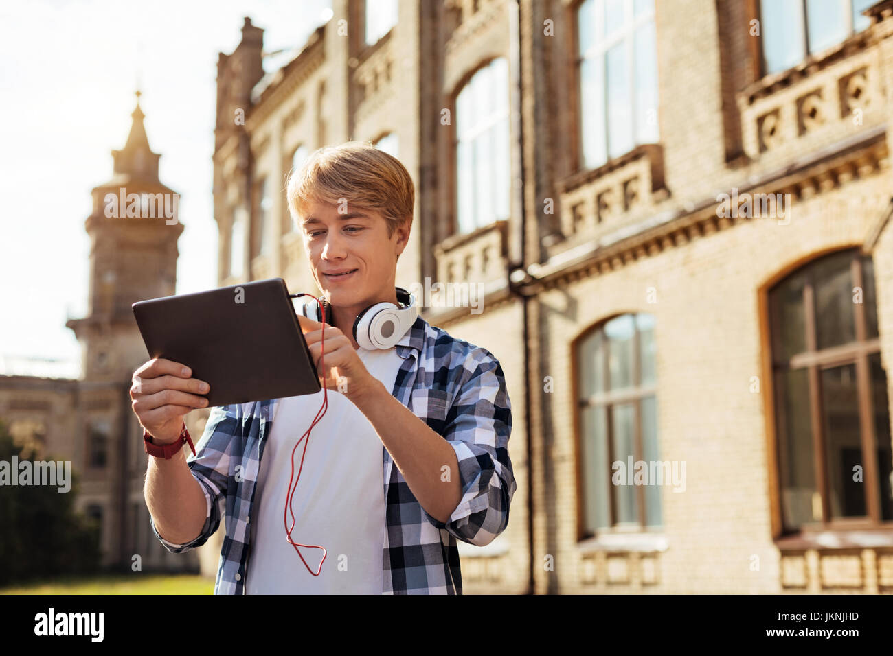 Positive savvy guy using his gadget Stock Photo - Alamy