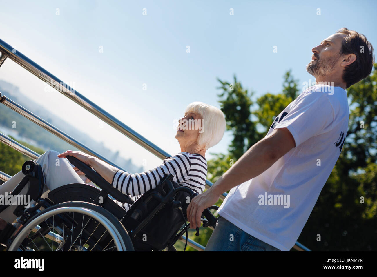 Committed gallant man taking care of elderly people Stock Photo - Alamy