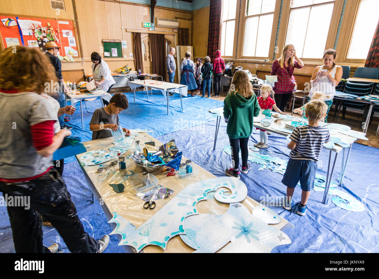 Caucasian adults and children at indoor creative arts and crafts ...