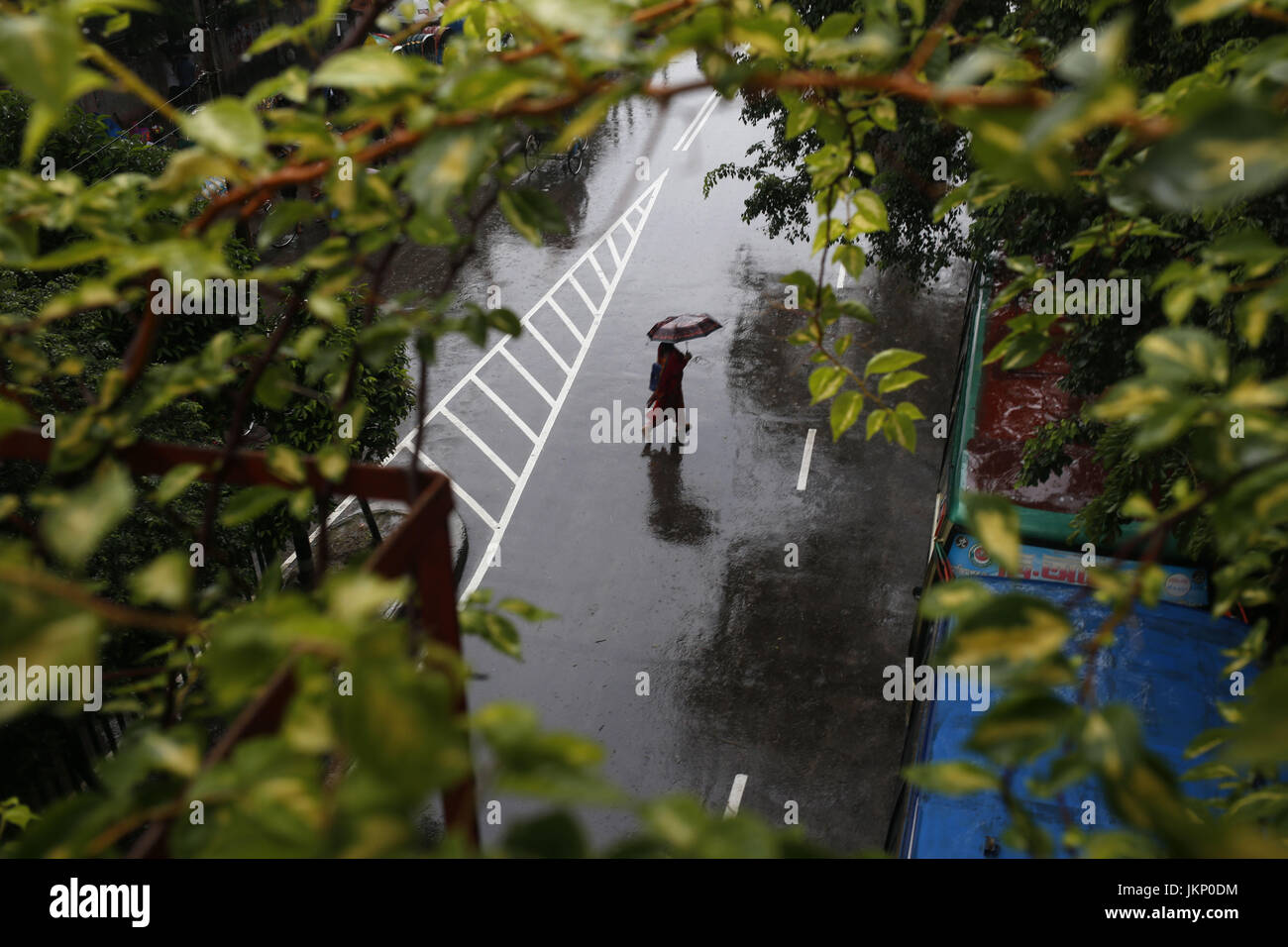Dhaka, Bangladesh. 24th July, 2017. A Bangladeshi woman carries umbrella to shield herself from ...