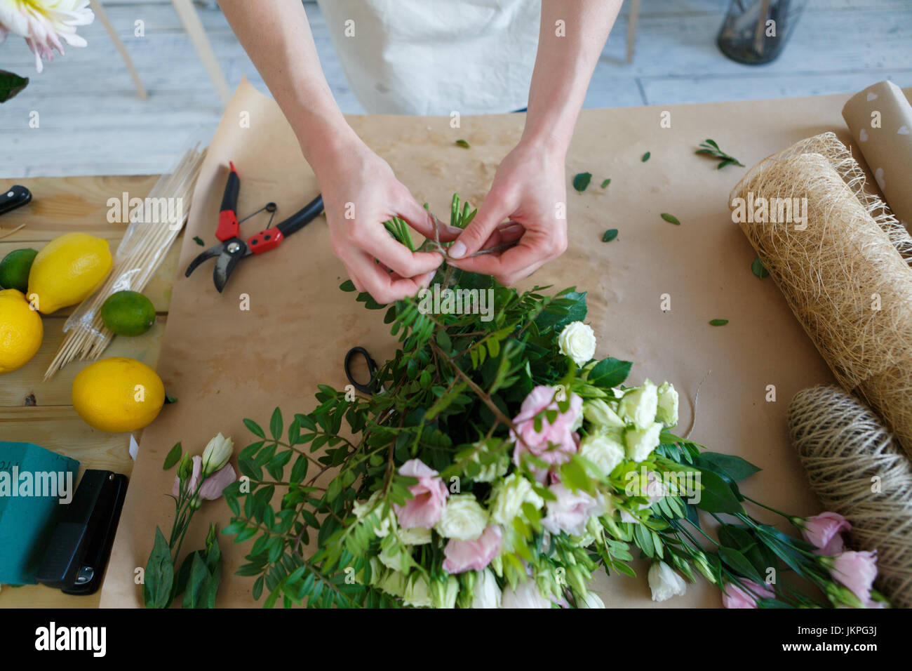 Florist makes bouquet on table Stock Photo - Alamy