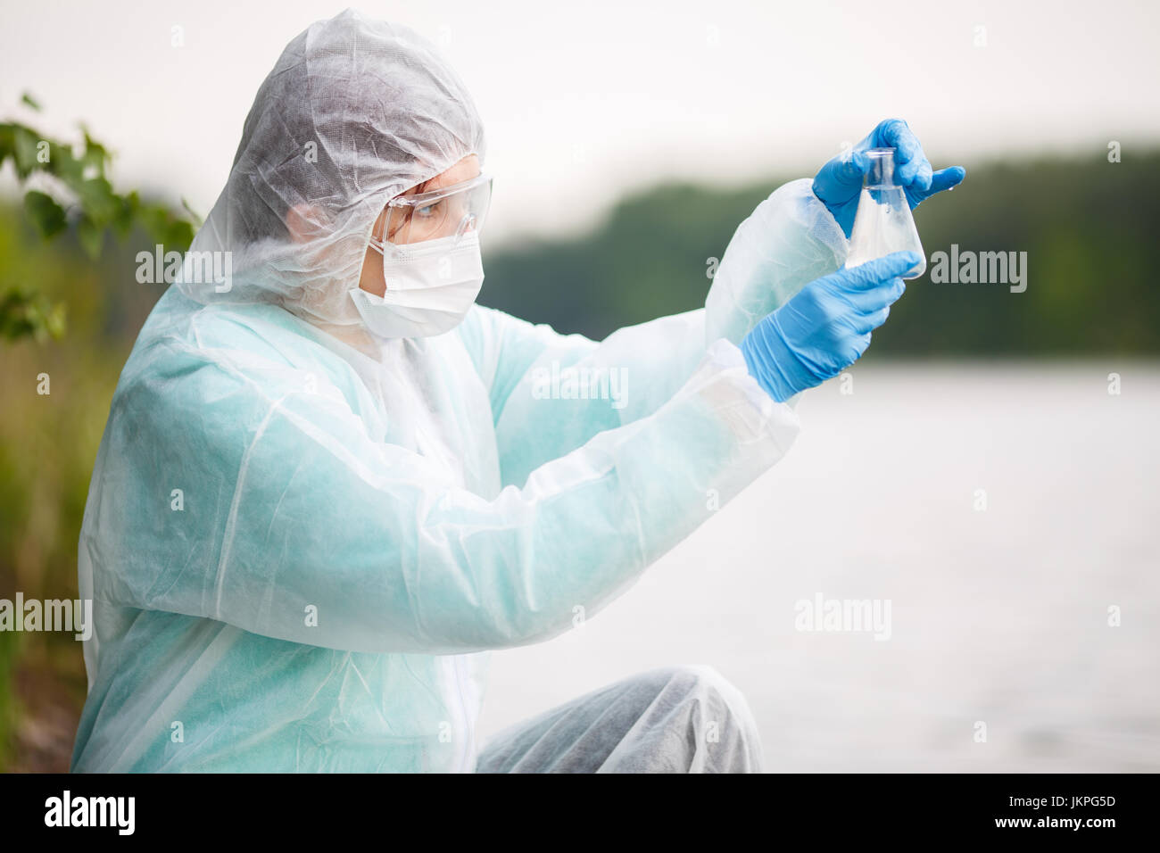Ecologist looks at water flask Stock Photo - Alamy