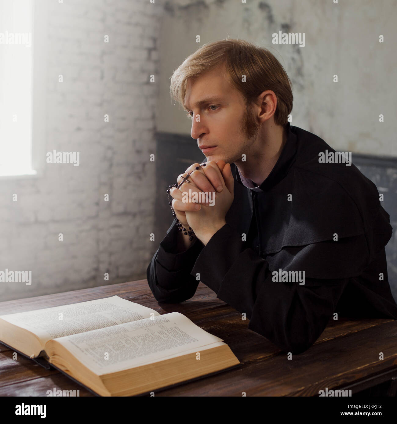 Portrait of handsome young catholic priest praying to God Stock Photo ...