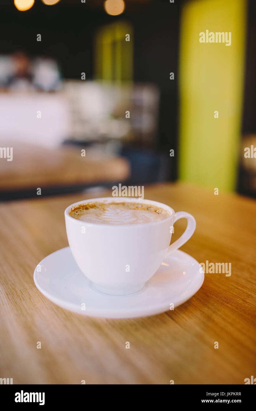 Close up view of white cup of coffee on wooden bar counter Stock Photo ...