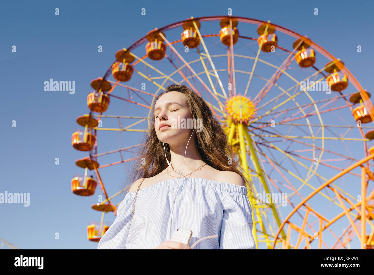 Portrait of beautiful young woman against ferris wheel Stock Photo - Alamy