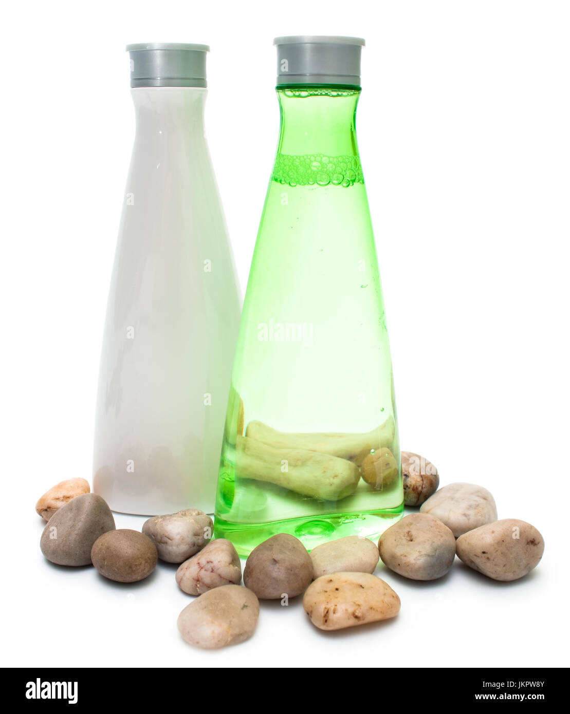 Spa bottles (green and white) with small stones isolated copy space ...