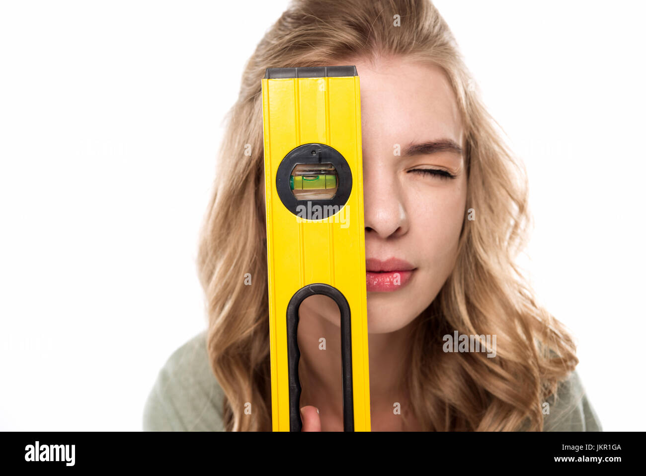 Young blonde woman looking through level tool, renovation concept Stock ...