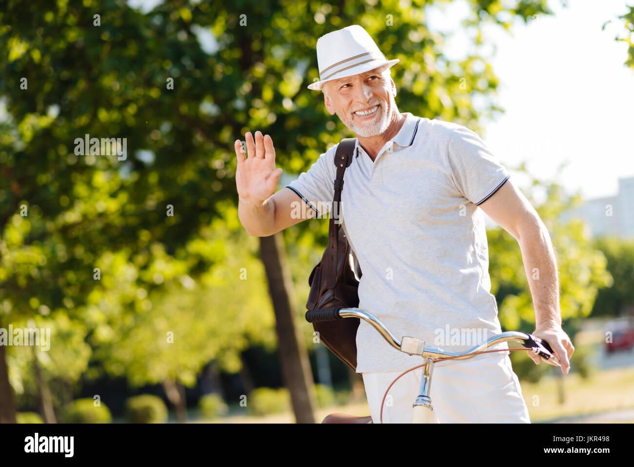 Positive delighted man waving his right hand Stock Photo - Alamy