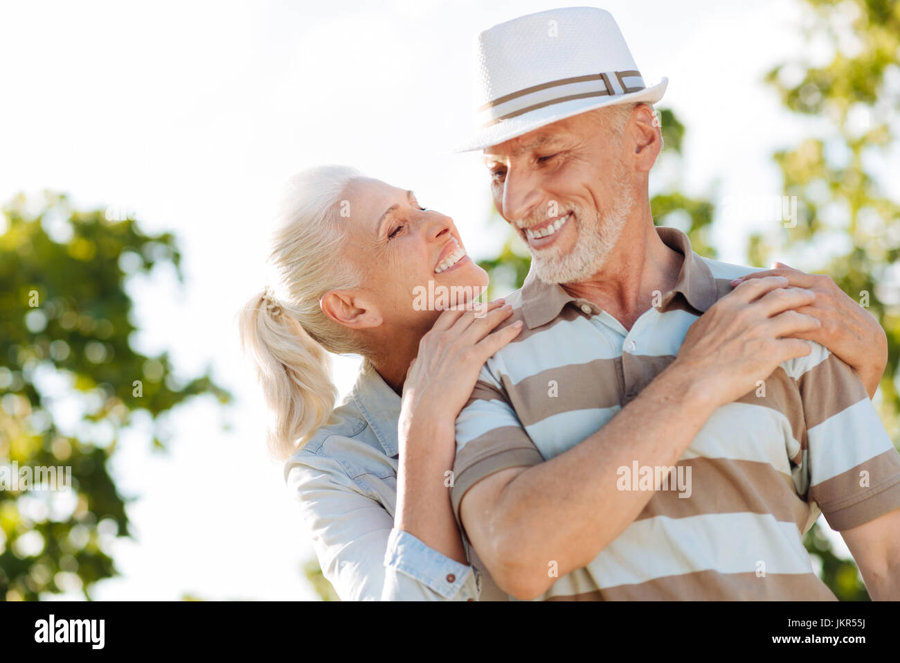 Handsome smiling man touching hand of his wife Stock Photo - Alamy