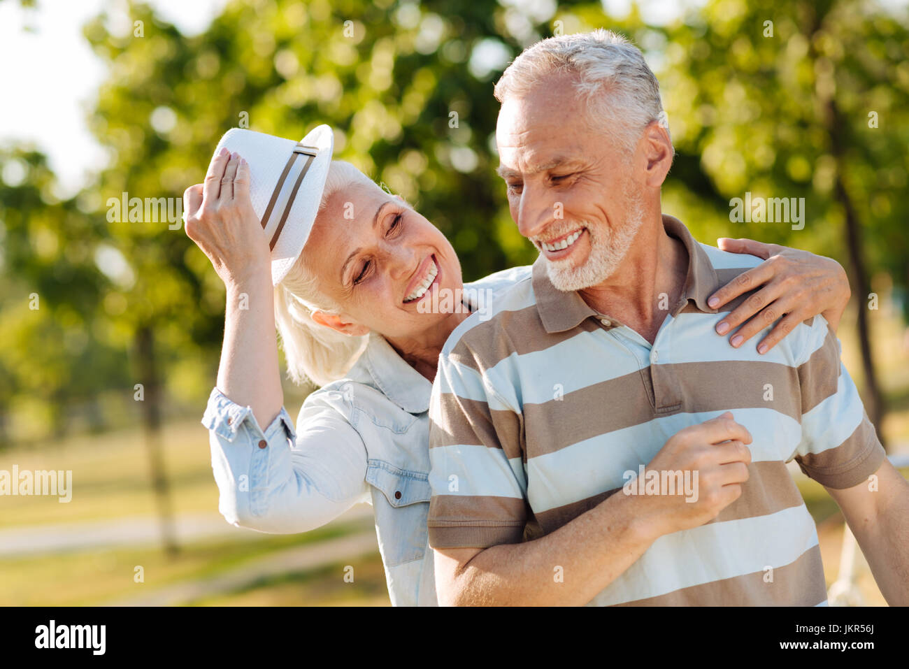 Pretty woman putting hat on her head Stock Photo - Alamy