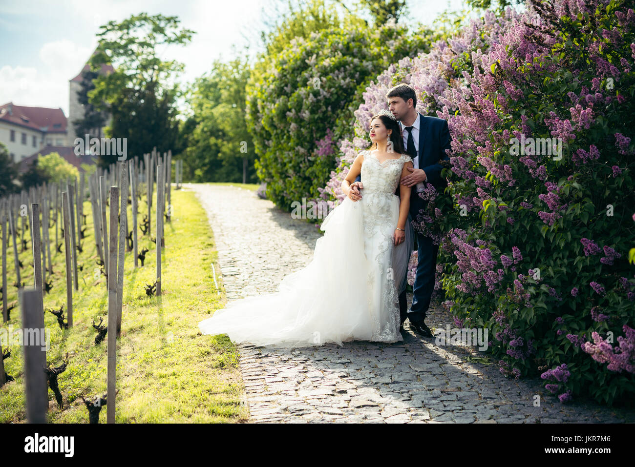 Horizontal photo of the groom hugging the charming bride back near the ...