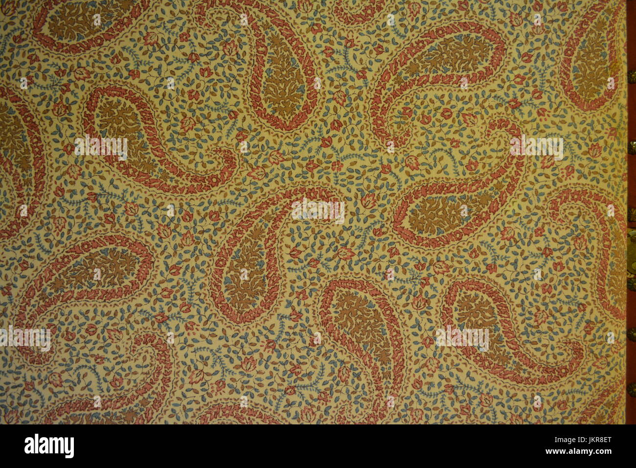 Elaborate faded patterned stretched fabric cloth material with scrolls ...