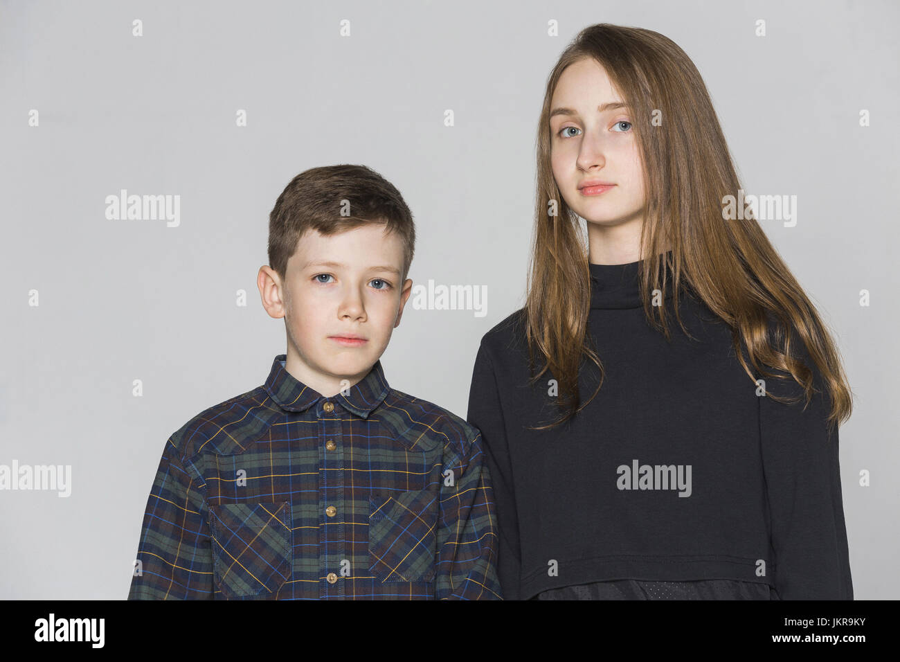 Portrait of siblings standing against white background Stock Photo - Alamy