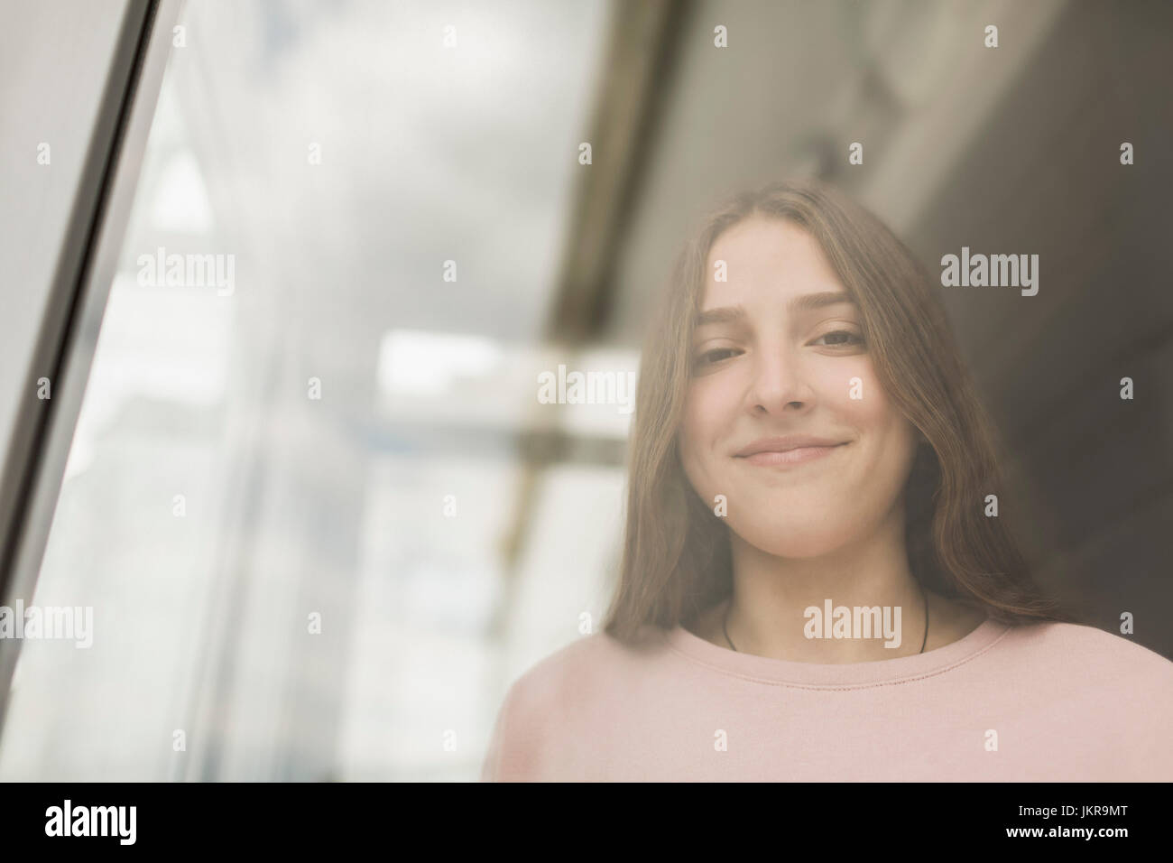 Low angle portrait of smiling teenage girl seen from window Stock Photo ...